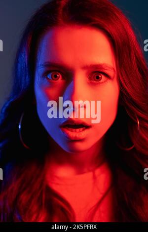 Young woman with glowing blue led band portrays bloodthirsty zombie ...