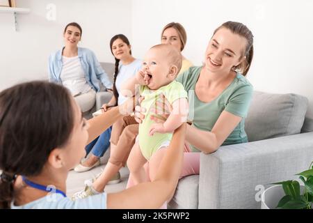 Female speaker with little baby giving course for expectant mothers in ...