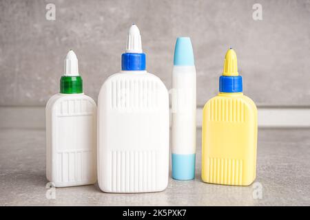 Different bottles and stick of glue on white background Stock Photo - Alamy