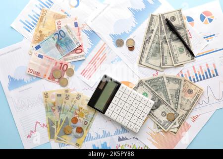 Different banknotes with coins, calculator and diagrams on blue ...