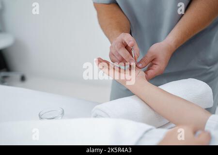 Doctor's hand perform professional acupuncture treatment in beauty spa ...
