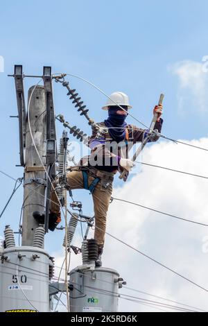 A lineman from a power company working on an electric pole in Cebu City ...