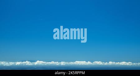 Long narrow band of cloud as a line between sky and ocean. Panoramic ...