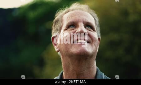 Grateful mature man smiling at sky with HOPE. One faithful senior ...