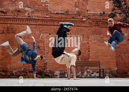 Freeze frame of male breakdance performer doing handstand pose with ...