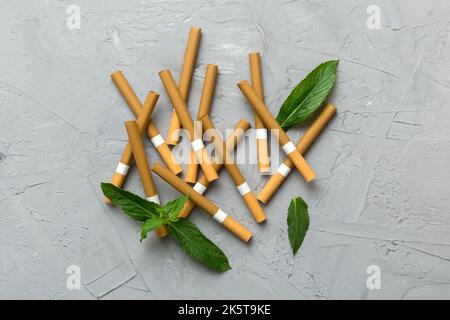 Menthol cigarettes and fresh mint leaves on colored background, Many ...