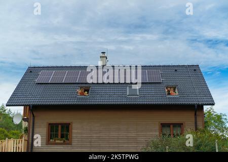 Happy family waving from skylight window in their new house with solar ...