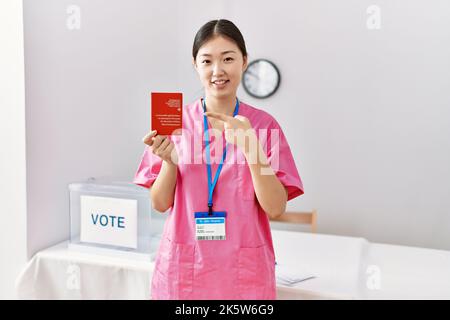Young nurse woman at political campaign holding usa vote badge annoyed ...