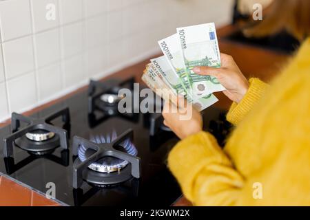 Counting euro banknotes near burning gas stove Stock Photo - Alamy