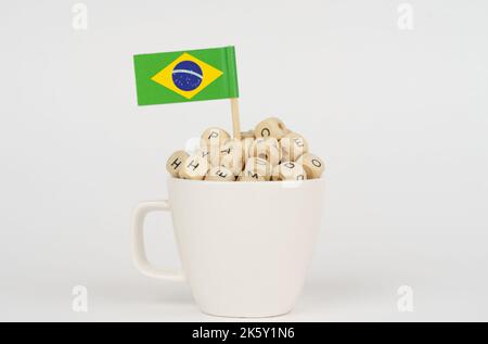 The flag of Brazil sticks out of a cup with dice on which letters are ...