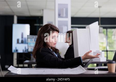 Architect discussing building 3d printed model on videocall in ...