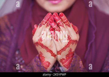Henna and wedding ring on bride hand, pray for doa session Stock Photo ...