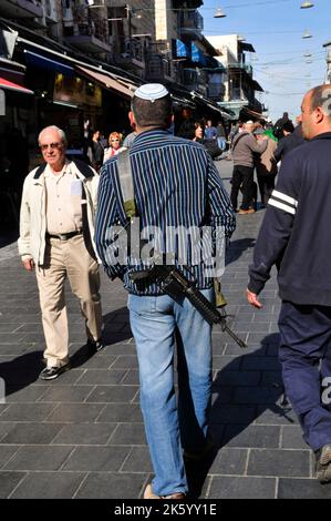 Jewish settlers with their rifles at the vibrant Machane Yehuda market ...