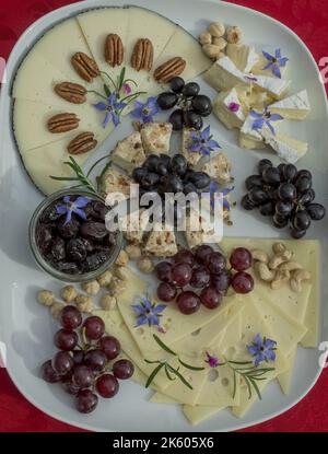 selection of cheeses with grapes and edible flowers Stock Photo - Alamy