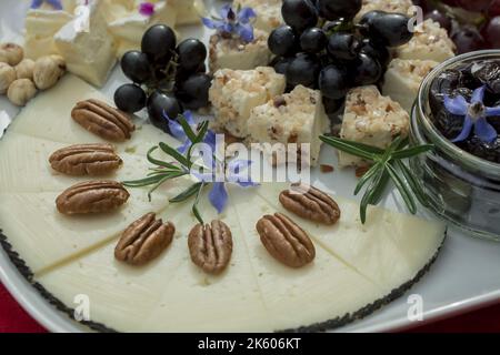 selection of cheeses with grapes and edible flowers Stock Photo - Alamy