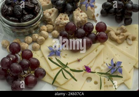 selection of cheeses with grapes and edible flowers Stock Photo - Alamy