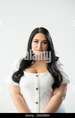 A charming brunette woman plus-size body positive practices sports in ...