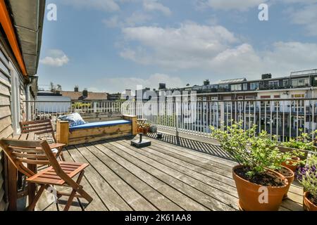 Comfortable chairs placed on wooden terrace near wall of residential ...