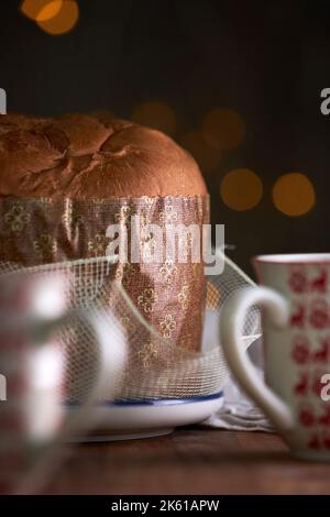 Uncut fresh baked artisan Christmas panettone cake on plate placed on ...