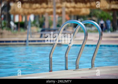 The swimming pool stainless steel handrail descending into tortoise ...
