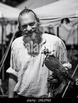 A vertical grayscale shot of a bearded man holding a falcon Stock Photo ...