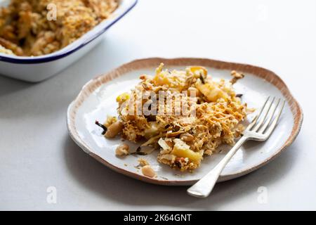 Vegan dish of parsnip, leek and bean crumble with crispy topping Stock ...