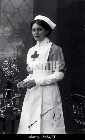 A VAD (Voluntary Aid Detachment) nurse taking care of injured men at a ...
