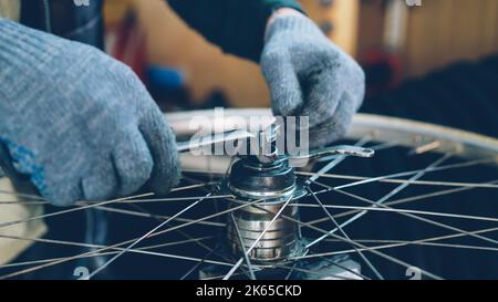 Mechanic hand with gloves carefully fixing suspension coil spring and ...