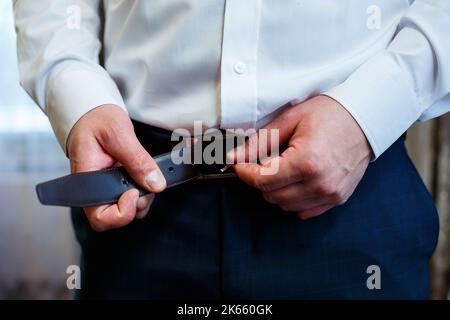 A man puts on a men's suit on the day of the wedding Stock Photo - Alamy