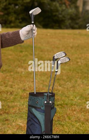 Gloved hand holding golf club Stock Photo - Alamy