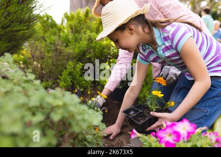 Caucasian mother and daughter spending time together in the garden ...