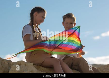 Teenage friends met in nature, talking and collecting a kite Stock ...