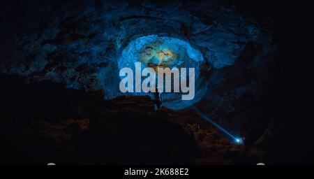 People with flashlights inside a cave Stock Photo - Alamy
