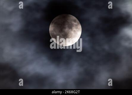 Ominous clouds pass in front of a full moon in the night sky Stock ...