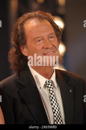 Singer Chris Andrews celebrates with pop singers Peter Petrell (C) and ...