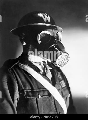 Portrait of an Air Raid Warden wearing a steel helmet and gas mask ...