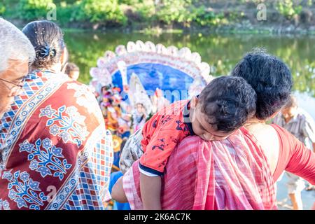 Devotees immerse an idol of Hindu goddess Durga in a makeshift water ...
