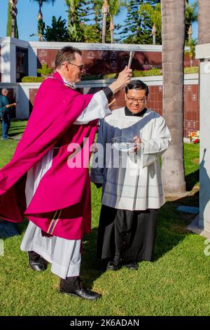 Using an aspergillium, a priest prepares to sprinkle holy water on a ...