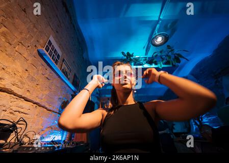 Beautiful female DJ dancing to techno in a small club Stock Photo - Alamy