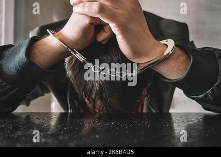 a dangerous criminal is handcuffed in prison for interrogation. A ...