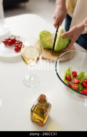 partial view of blurred man with glass of cappuccino holding smartphone ...
