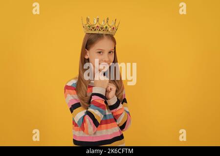 Teen child in queen crown isolated on yellow background. Princess girl ...