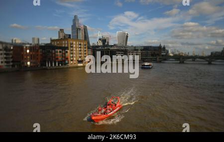 A Thames rocket boat travels towards Millennium Bridge followed by a ...
