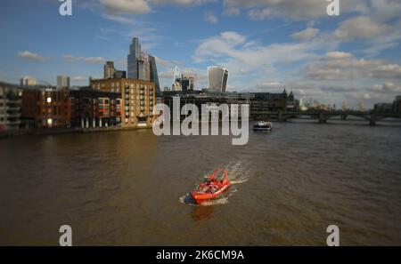 A Thames rocket boat travels towards Millennium Bridge followed by a ...