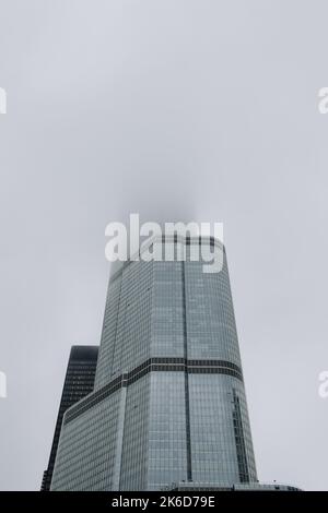 A vertical shot of a tall skyscraper covered in mist in Chicago ...