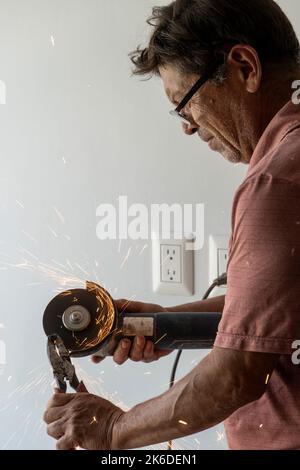 A Mexican man using an angle grinder Stock Photo - Alamy