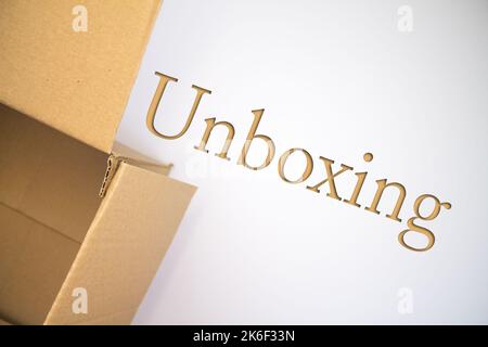 Unboxing word with cardboard box. Brown folded card box Stock Photo - Alamy