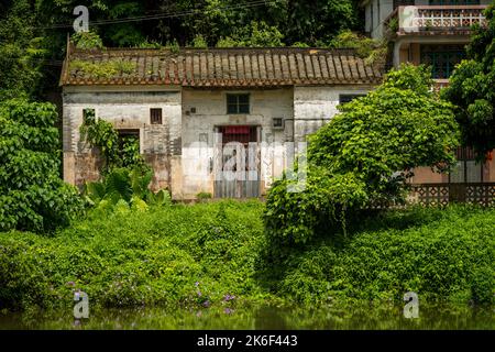 Traditional Chinese village house next to a small lagoon, Nam Chung ...