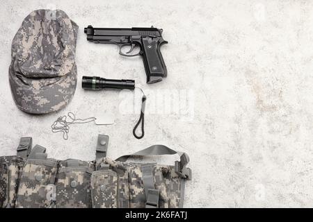 Military uniform, gun, flashlight and tag on color background Stock ...