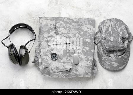Military uniform, tag, compass and headphones on light background Stock ...